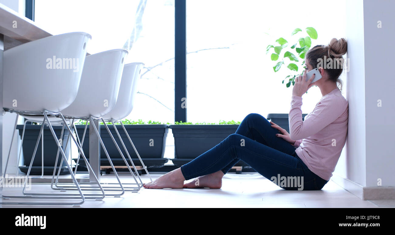 beautiful young women using mobile phone on the floor of her luxury ...