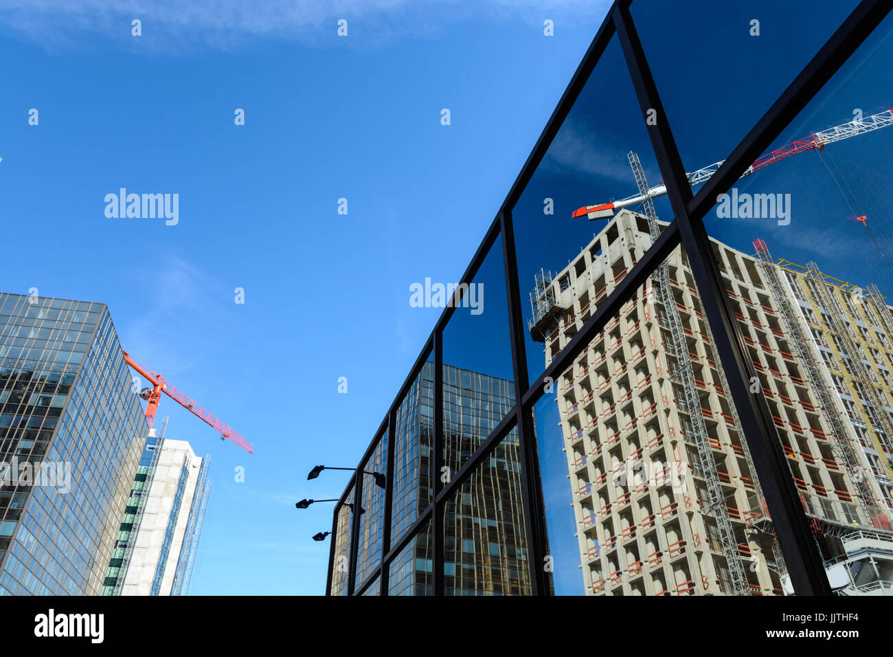 Low angle view and in reflection of two concrete buildings under ...