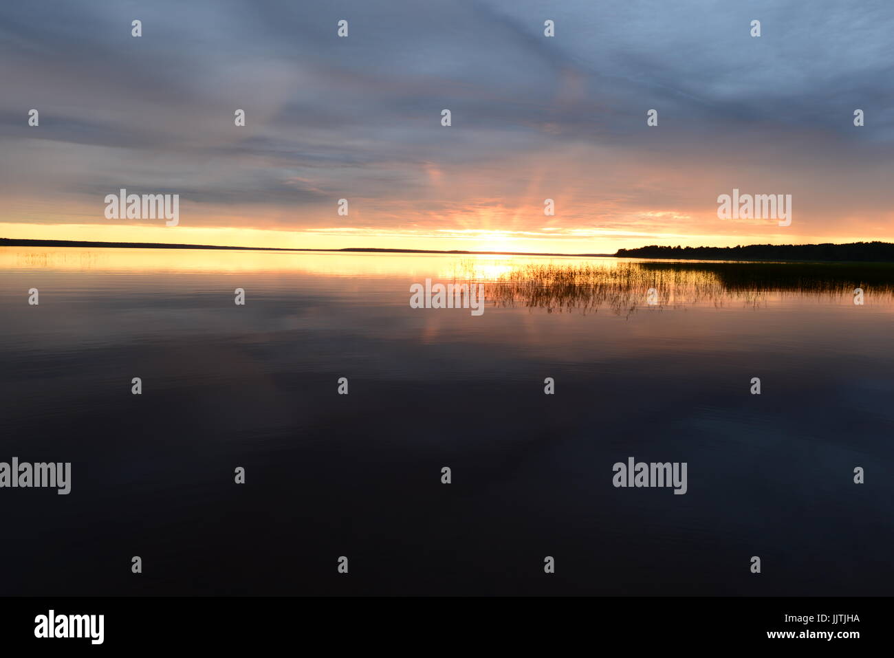 Sun rays at sunset above the water surface Stock Photo - Alamy