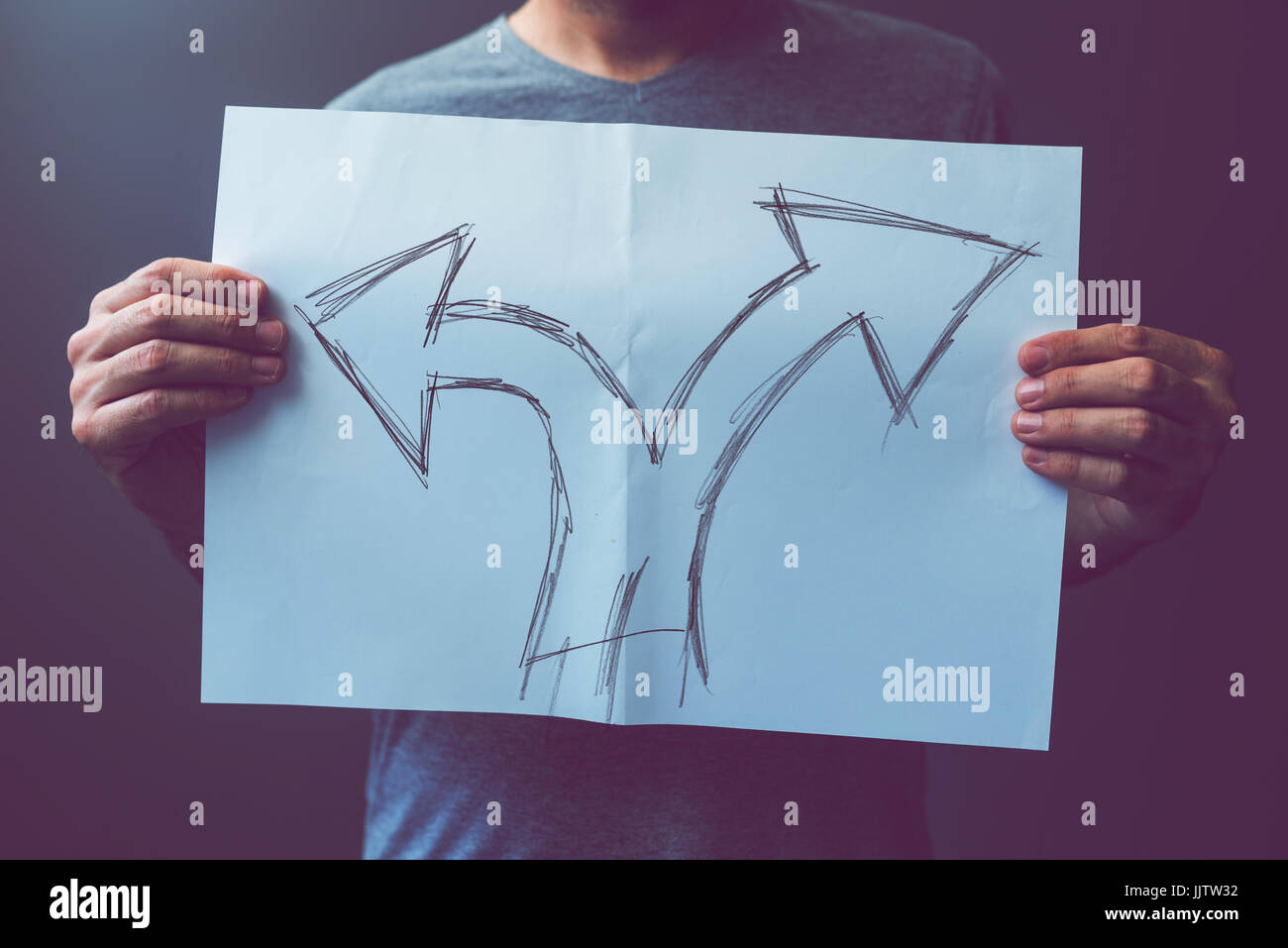 Choices and options, man with two direction arrows on paper Stock Photo ...