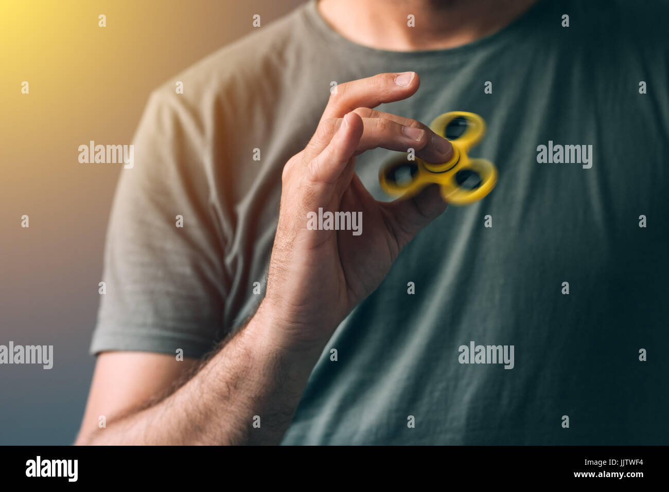 Man playing with fidget spinner, very popular modern toy for relaxation ...