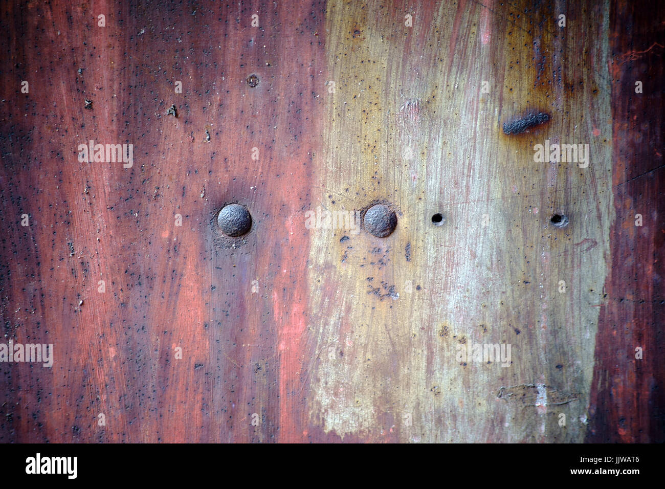 The closeup of a rusty metal surface with rust bubbles and rusty rivets ...