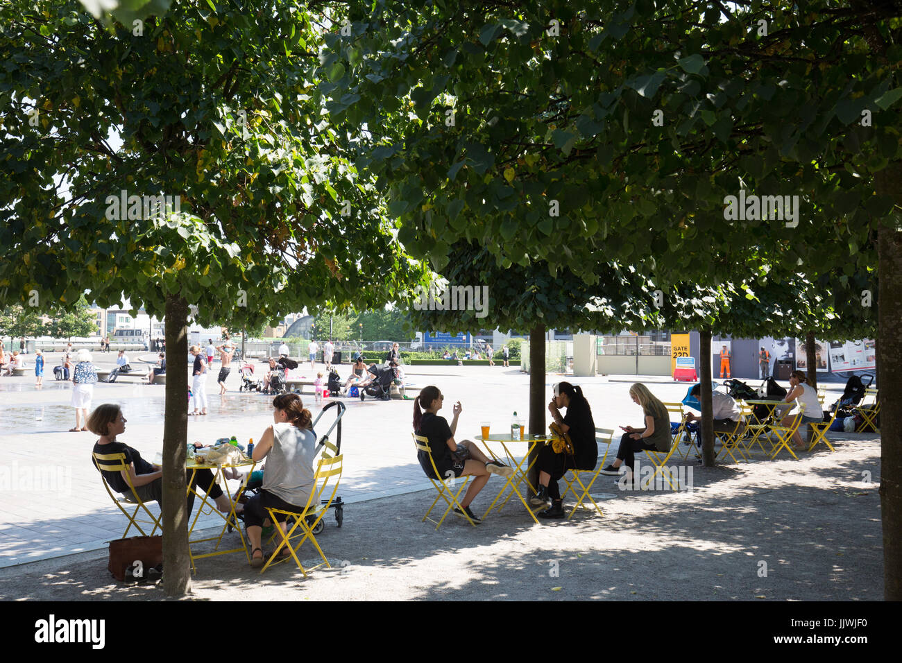 Granary Square, King Cross. Londoners enjoy a shady seating area in ...