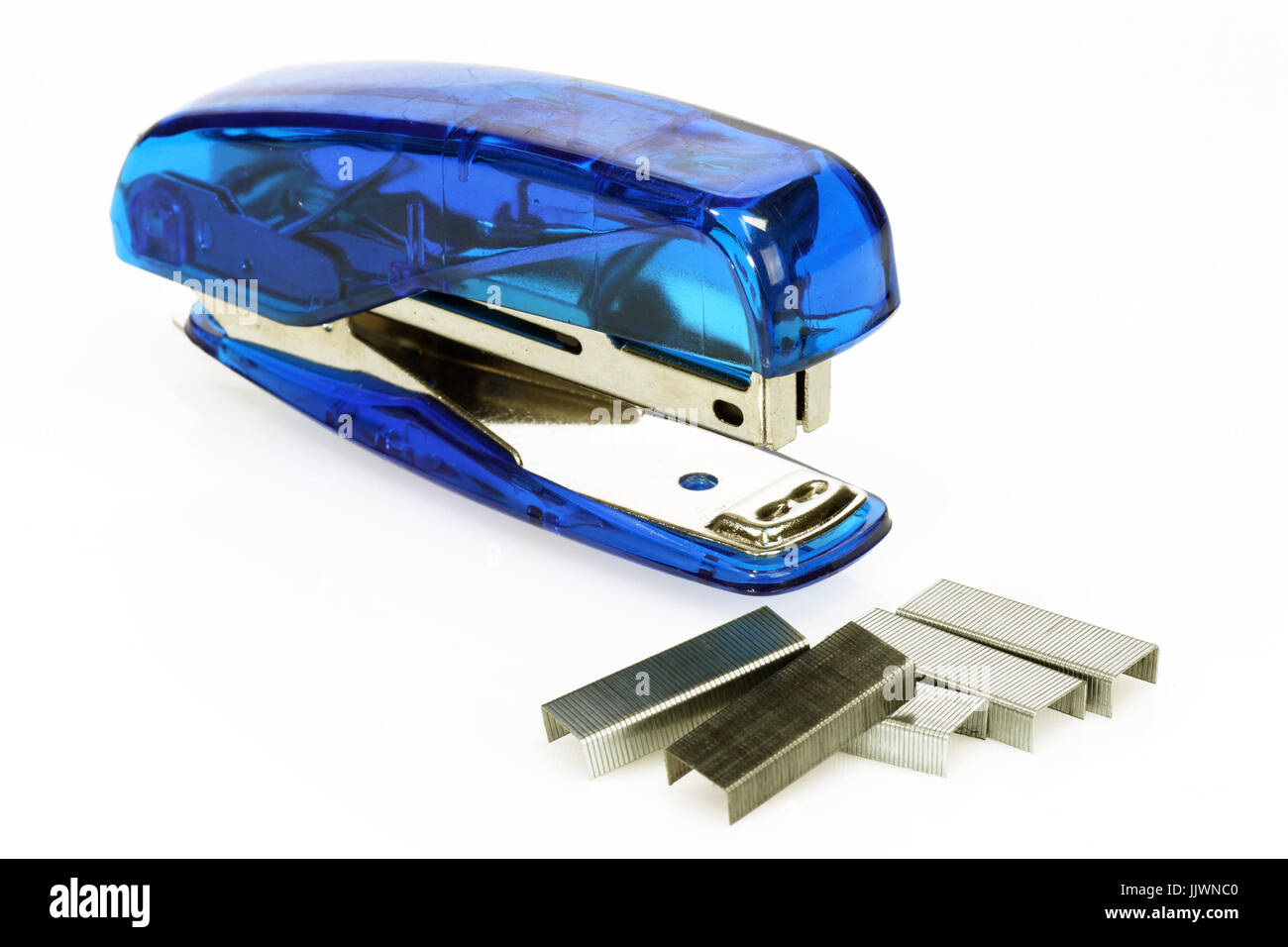 Office stapler and clips on bright background Stock Photo - Alamy