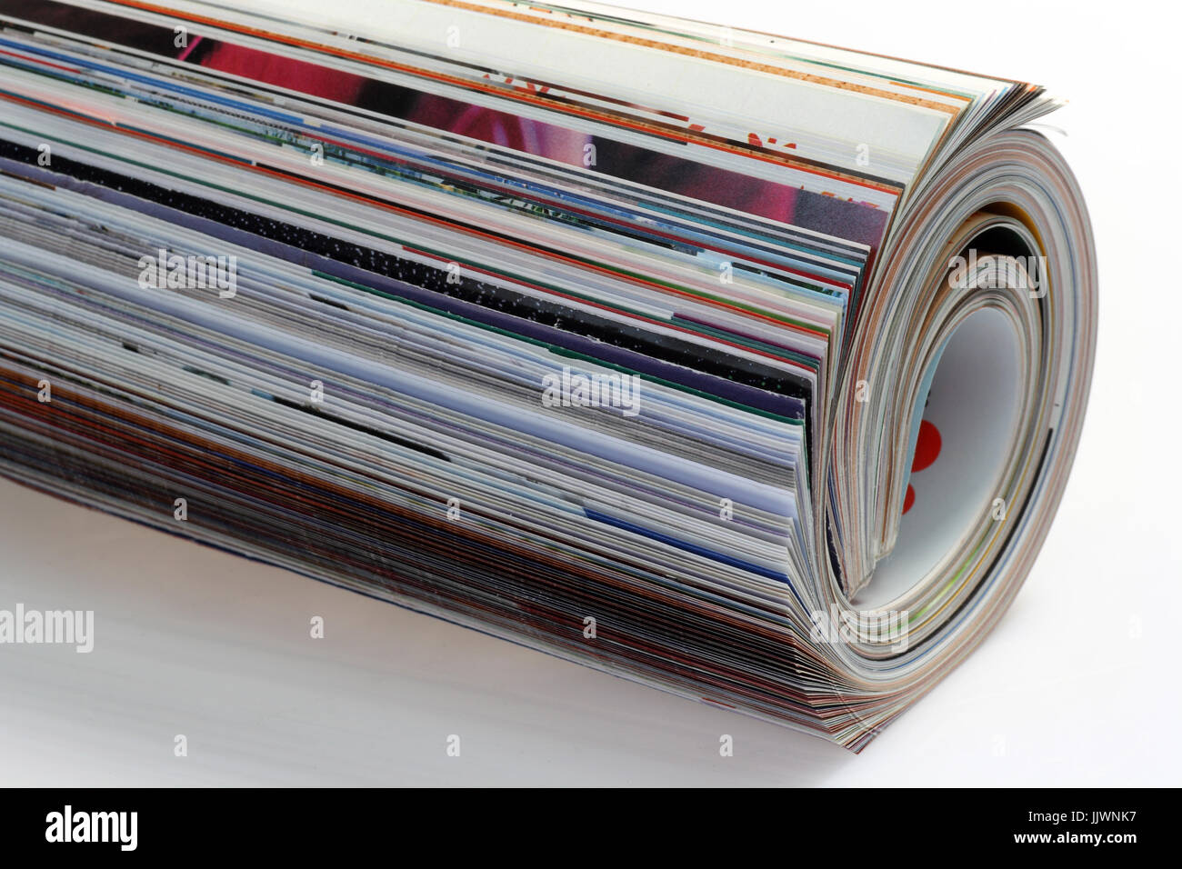 Rolled up magazine on bright background Stock Photo - Alamy