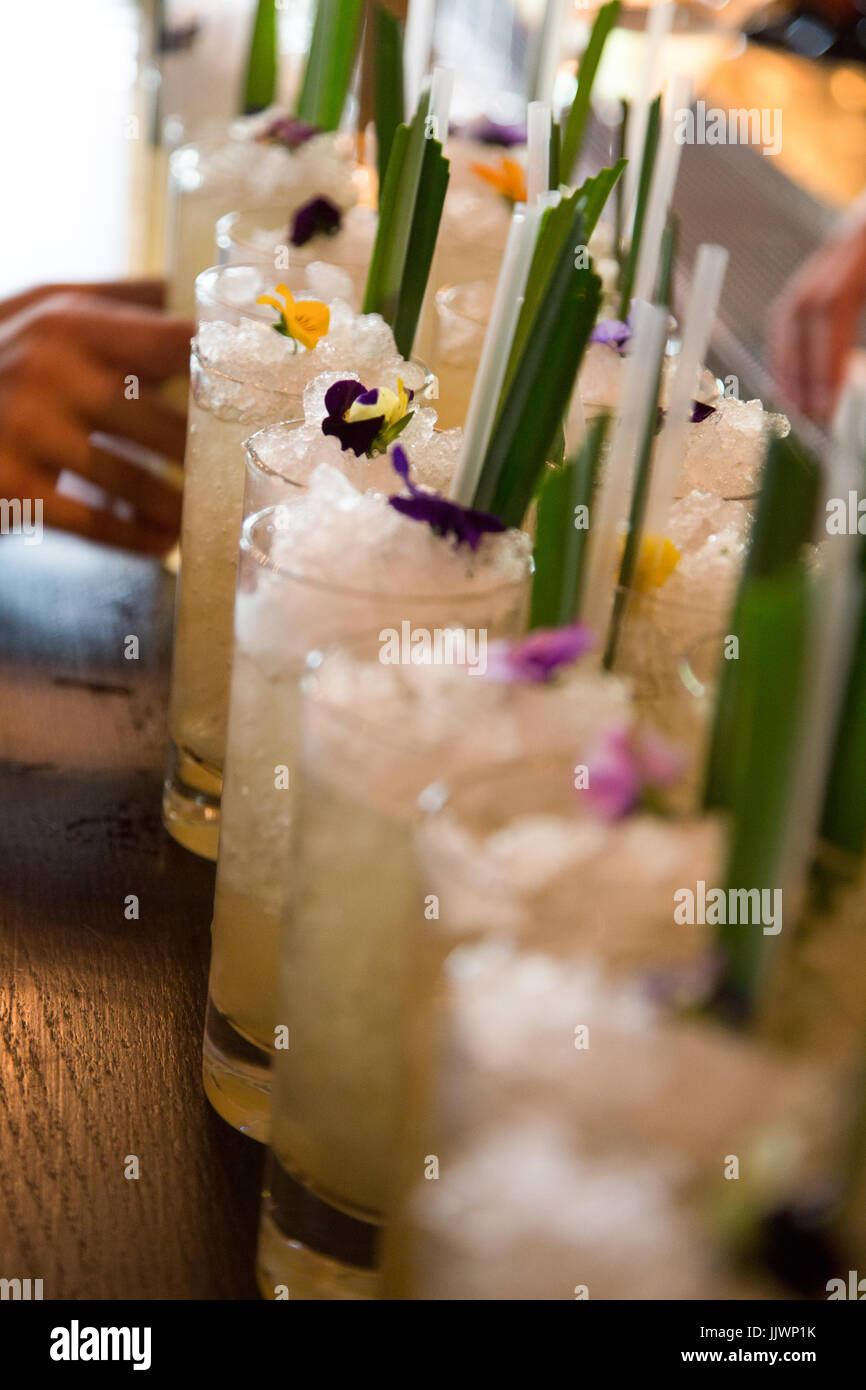 Cocktails lined up in a bar with pansy flowers on top Stock Photo - Alamy