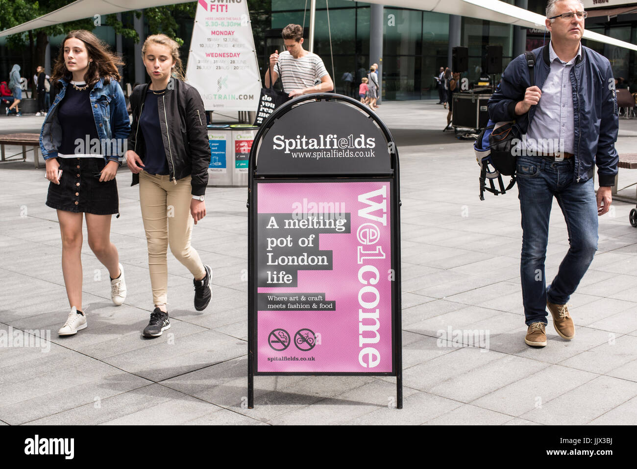 People walking next to street sign promoting Spitalfields market as a ...