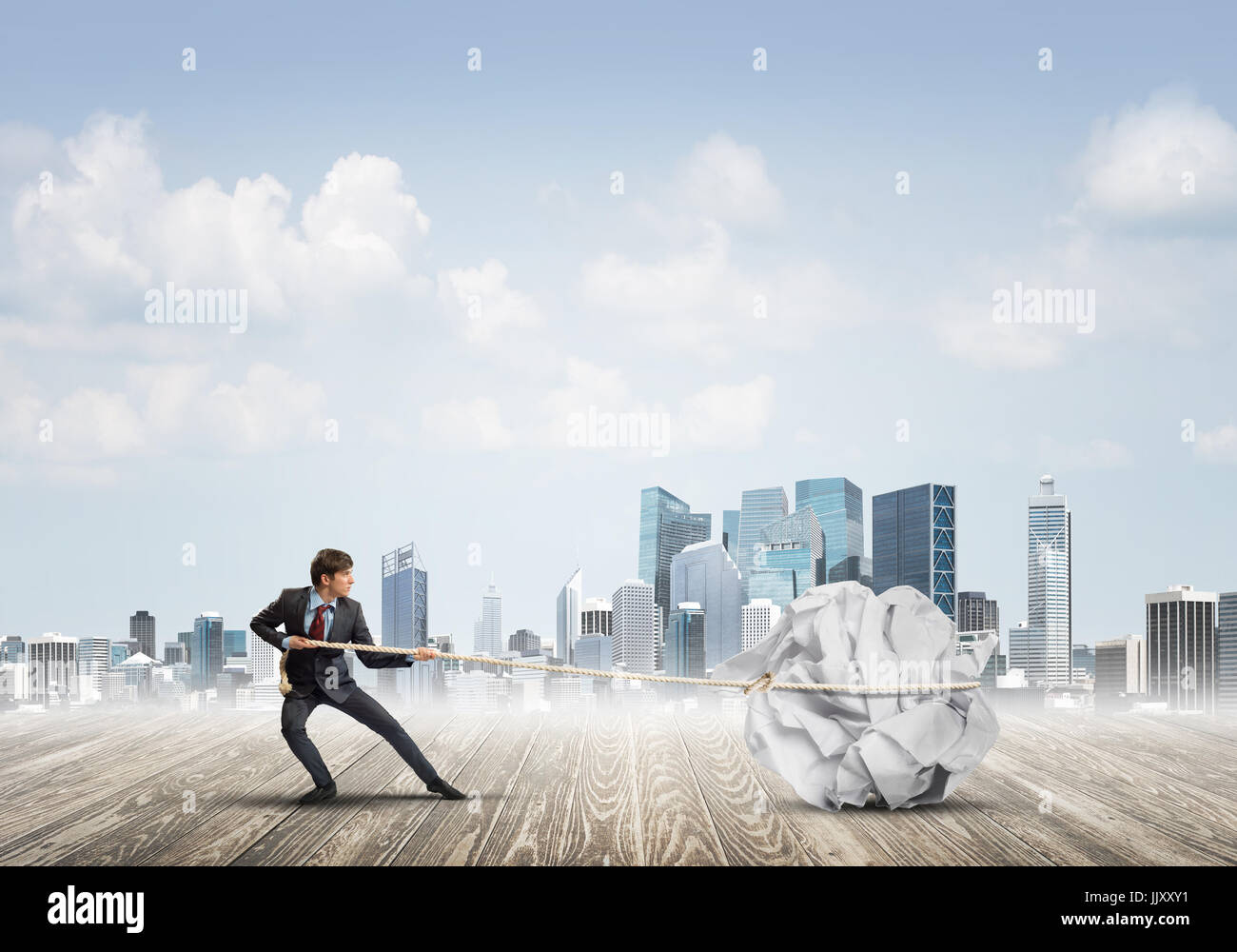 Man pulling with effort big crumpled ball of paper as creativity sign ...