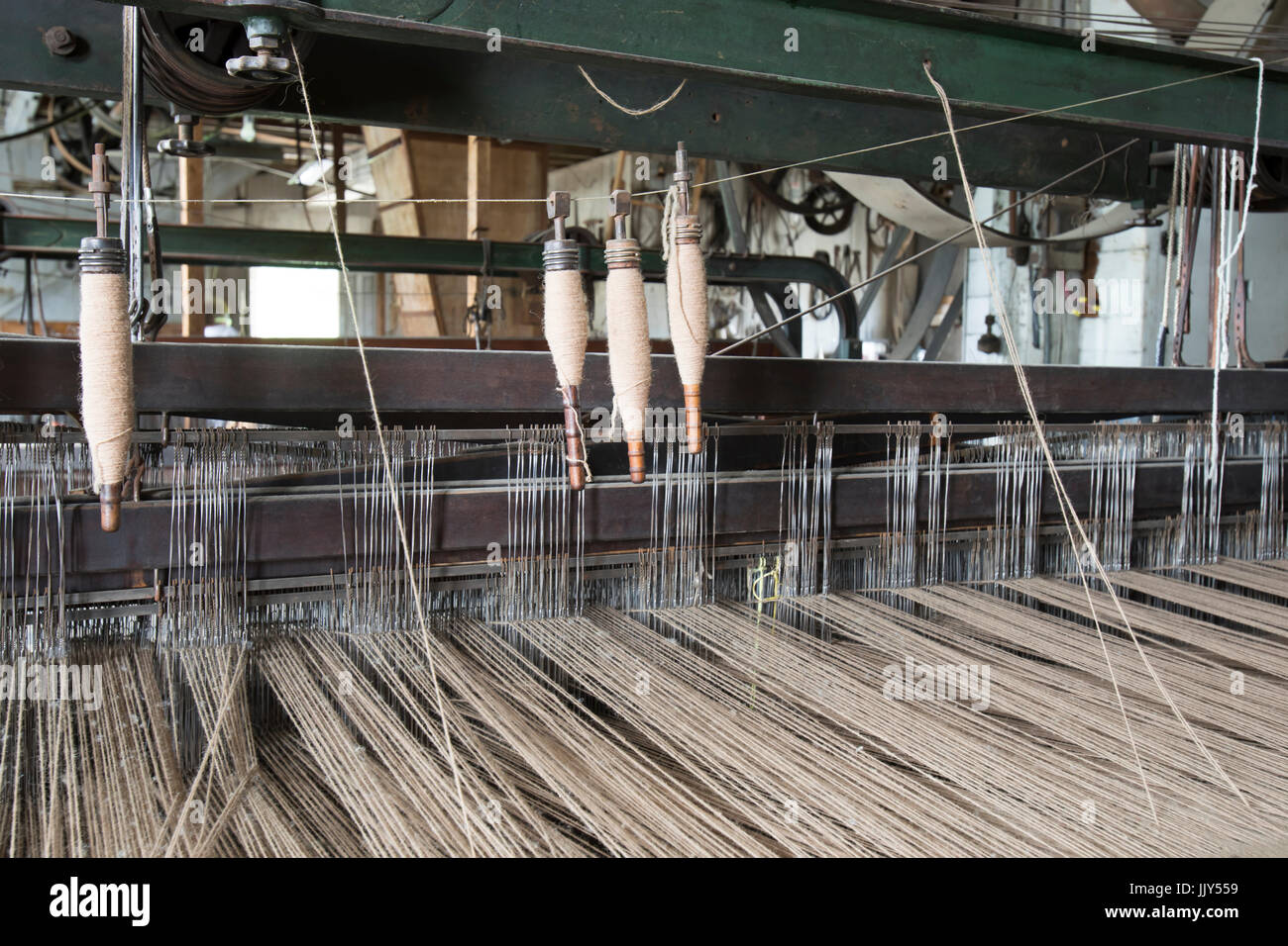 Spools of yarn over antique loom inside vintage mill Stock Photo - Alamy