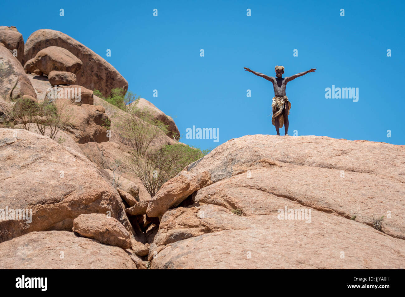 At the Damara Living Museum, a male tribe member stands on top of a ...