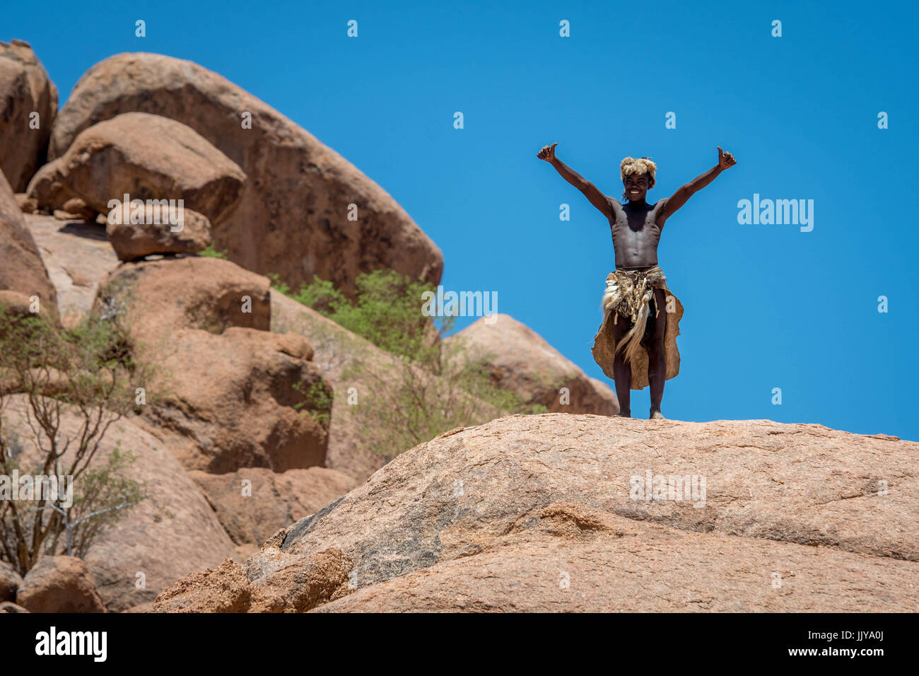 At the Damara Living Museum, a male tribe member stands on top of a ...