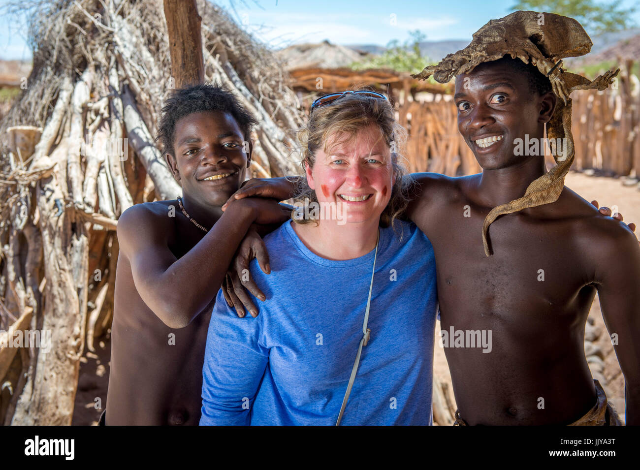 Tourist posing with Damaran men at the Damara Living Museum in ...