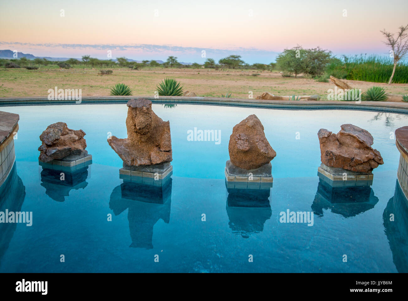 A pool featuring four rock sculptures in the Namib-Naukluft desert in ...