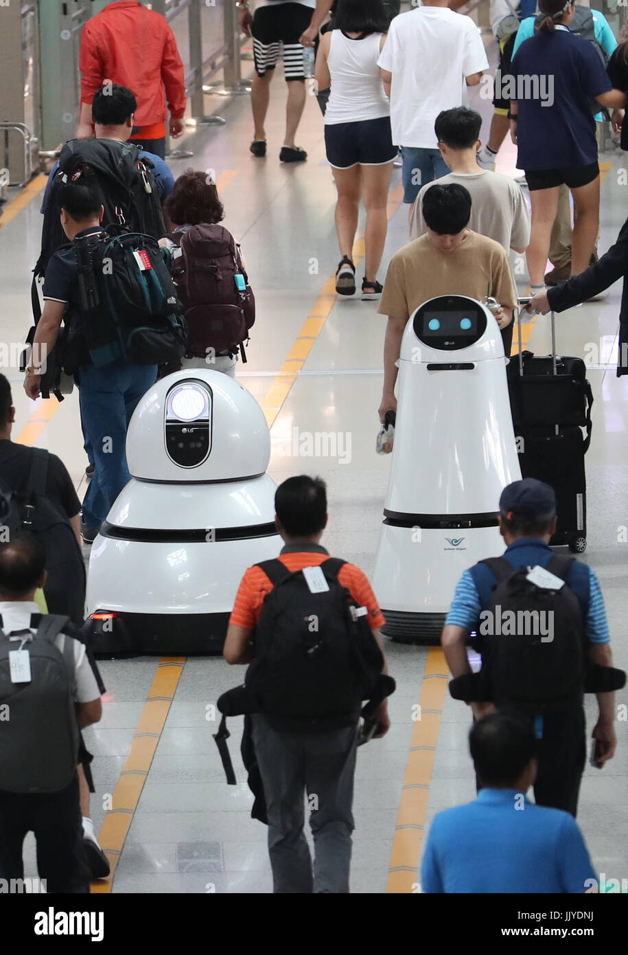 Guide, cleaning robots at airport A guide robot (L) and a cleaning ...