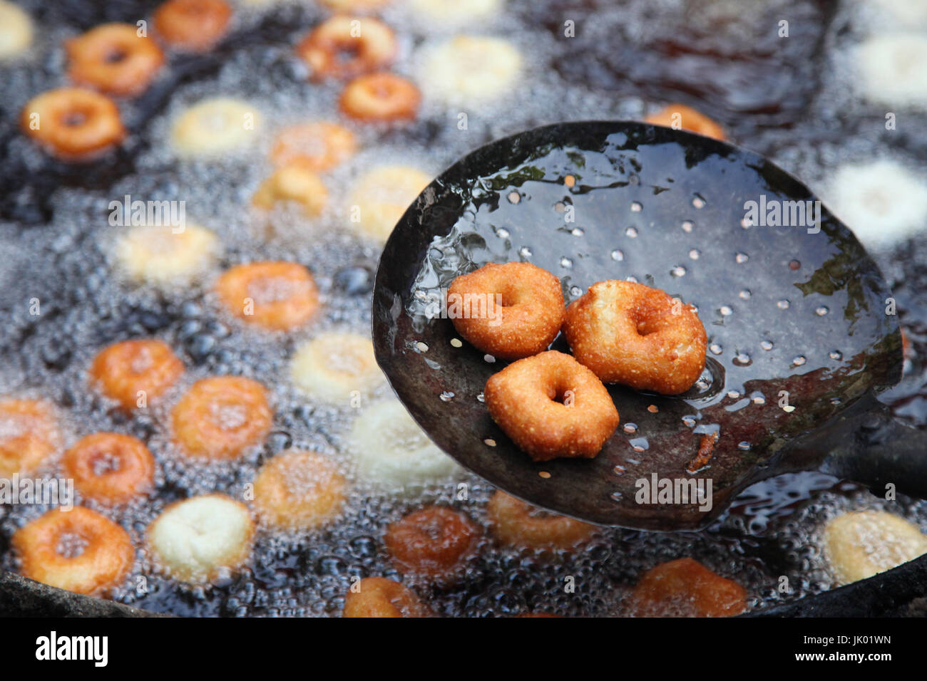 Deep frying medu vada in the pan. Medu Vada is a savoury snack from ...