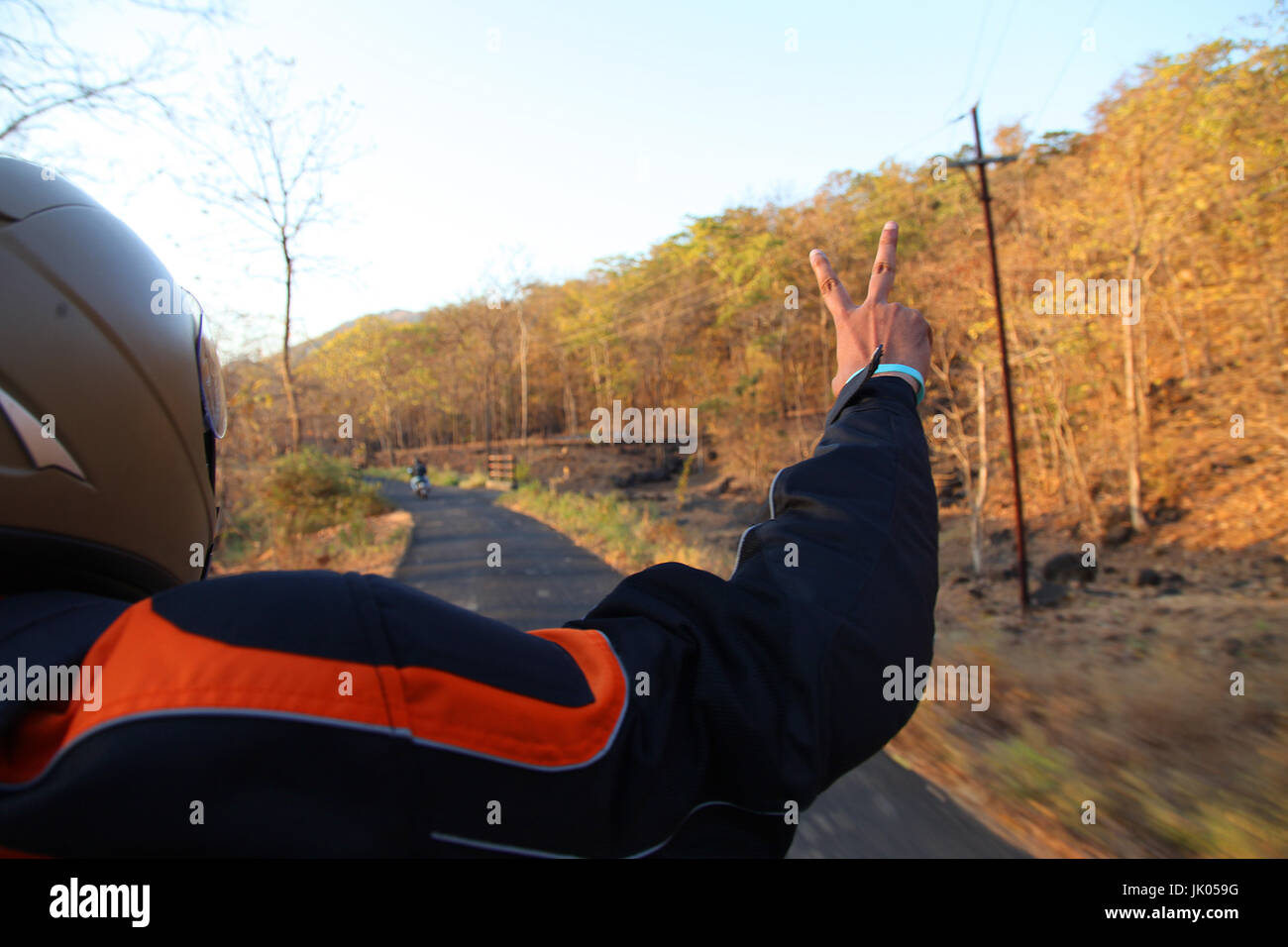 Biker driving a motorcycle rides along the asphalt road Stock Photo - Alamy