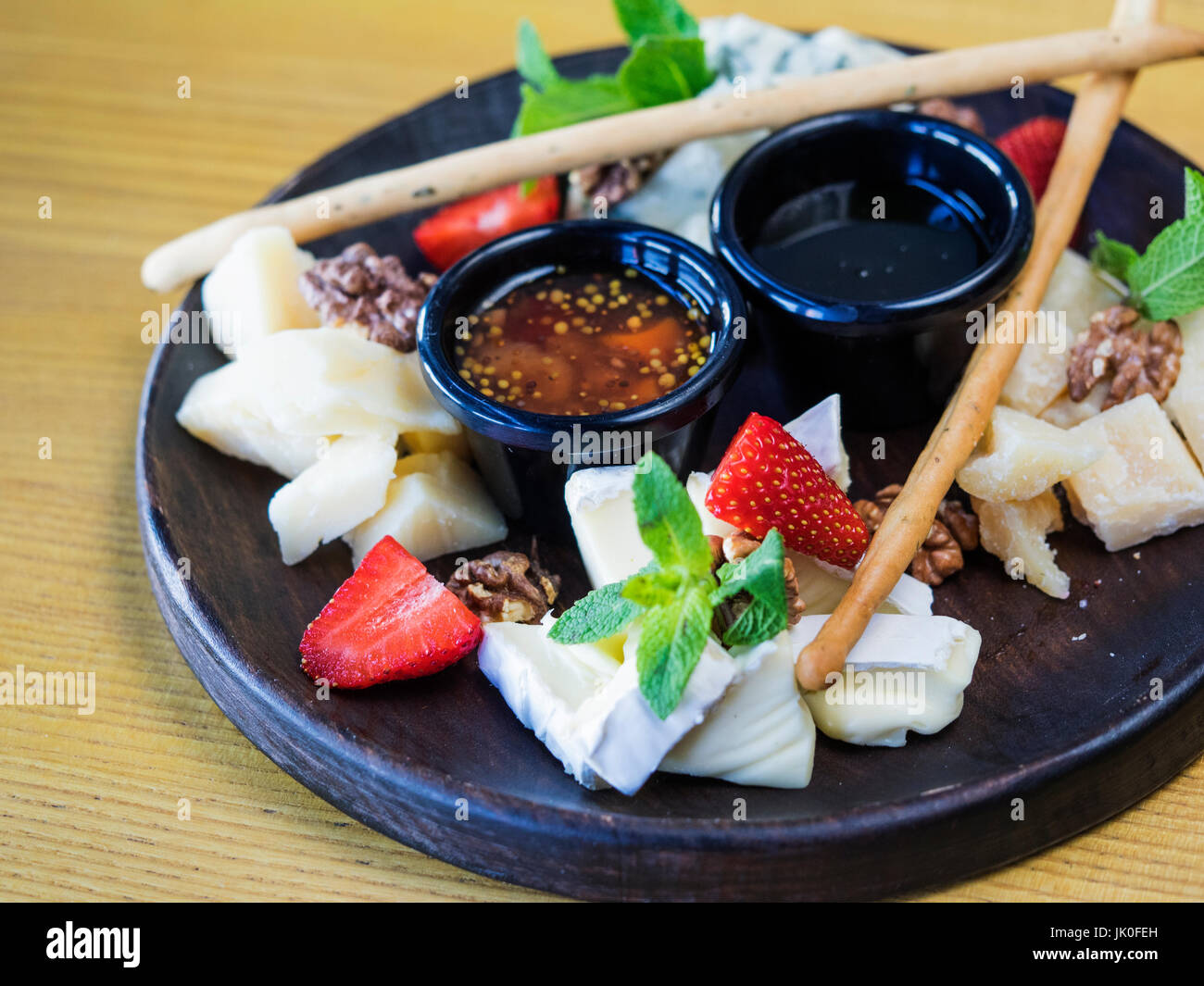 Italian chesse plate on black dish Stock Photo - Alamy