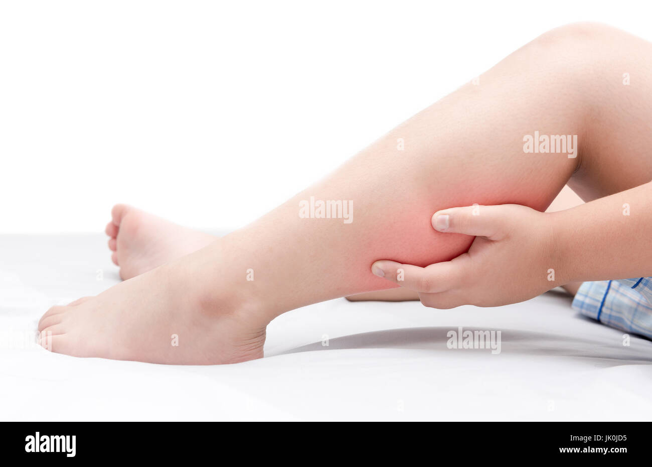 Leg pain or calf muscle in a boy on bed isolated on white background ...