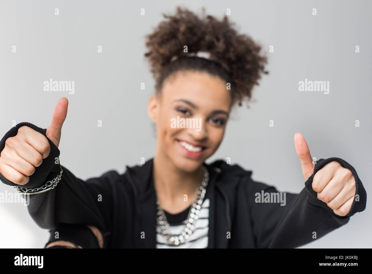 portrait of african american girl showing thumbs up isolated on grey ...