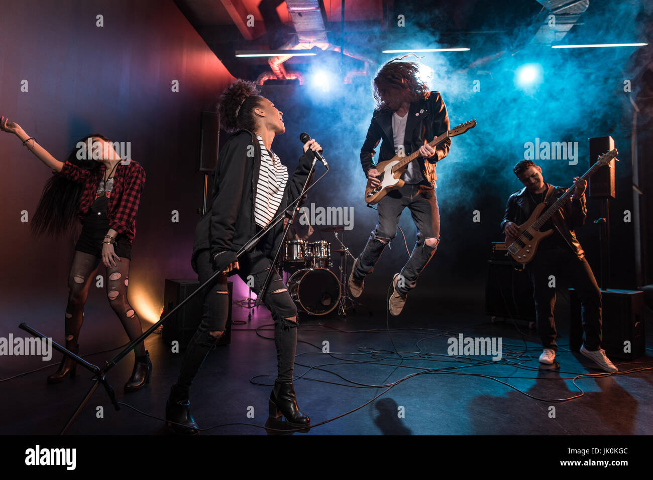 Young multiethnic rock and roll band performing hard rock music on ...