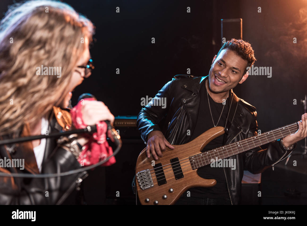 Male singer with microphone and rock and roll band performing hard rock ...