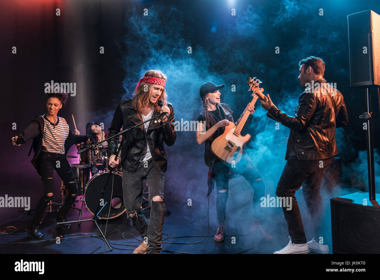 Handsome singer with rock and roll band performing music on stage Stock ...