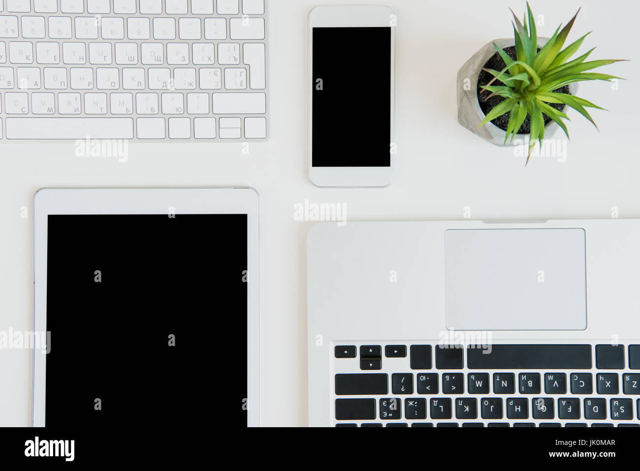 Top view of laptops with digital tablet and smartphone on table top ...