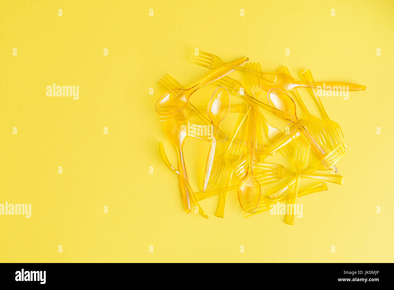 top view of pile of spoons and forks isolated on yellow Stock Photo - Alamy