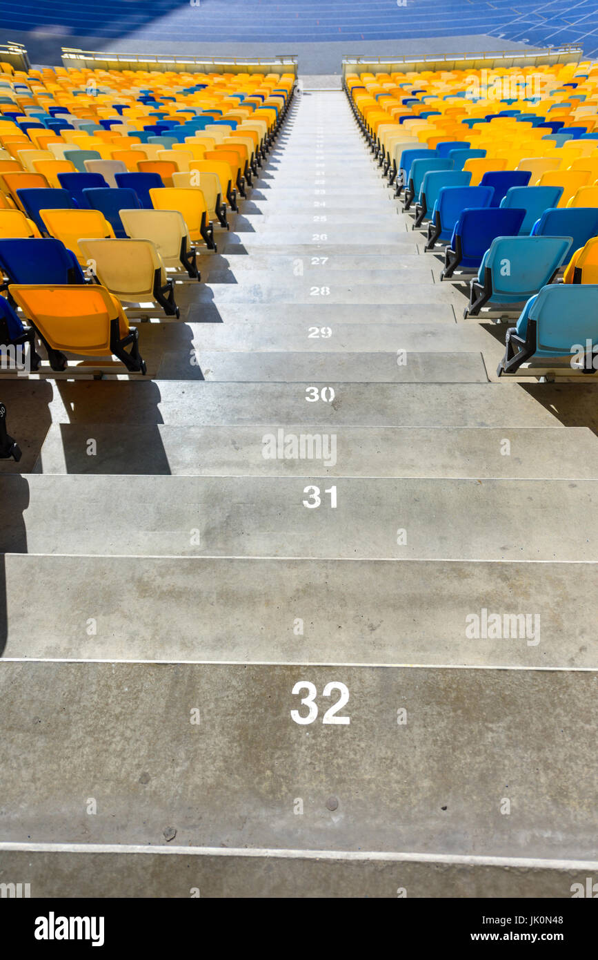 rows of yellow and blue stadium seats and stadium stairs Stock Photo ...