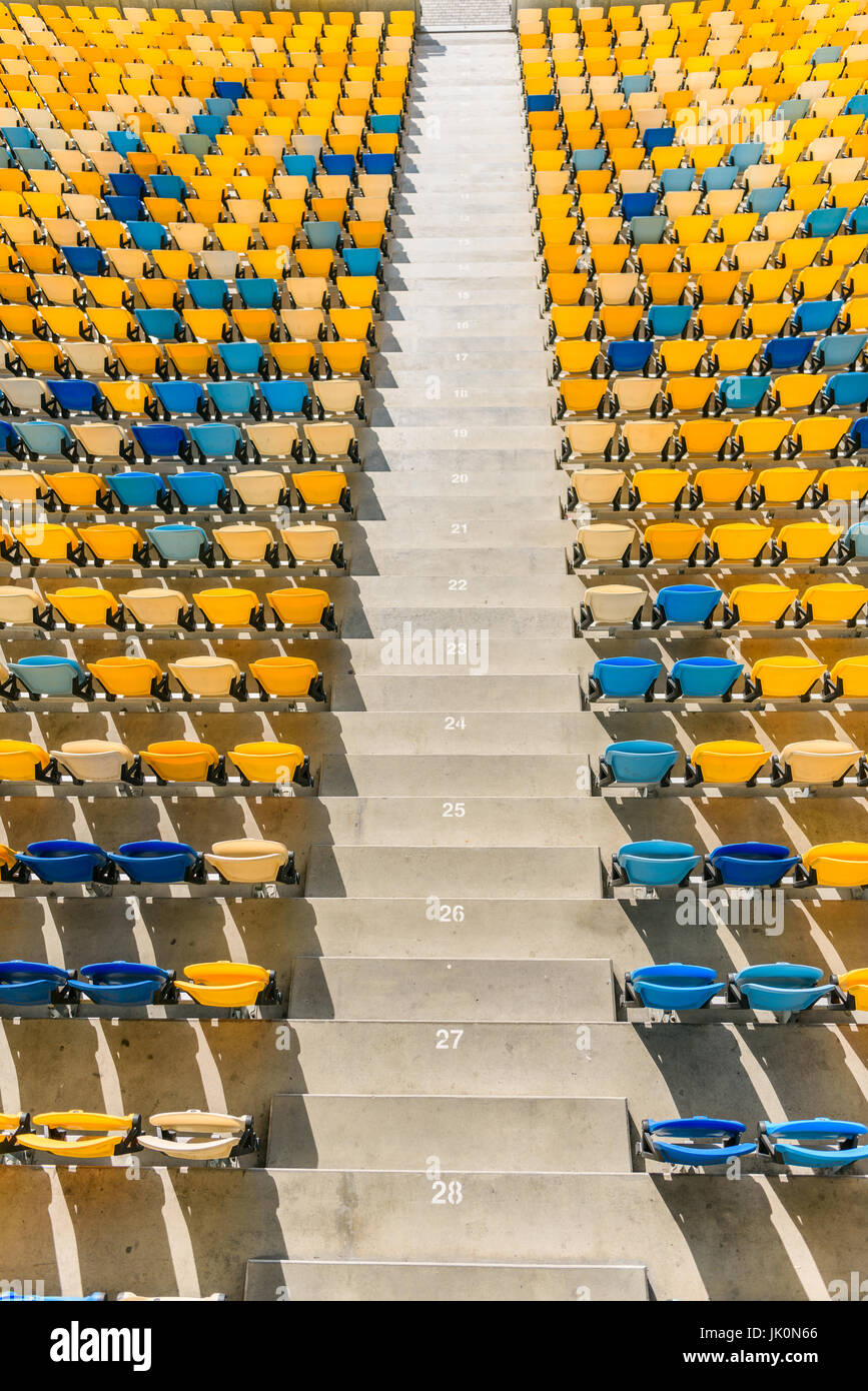 rows of yellow and blue stadium seats and stadium stairs Stock Photo ...