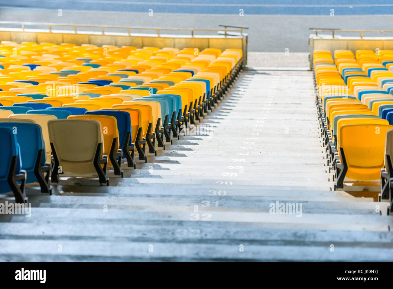 rows of yellow and blue stadium seats and stadium stairs Stock Photo ...
