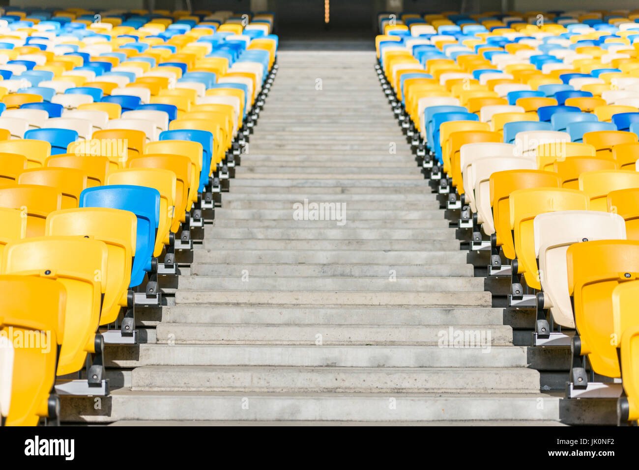 rows of yellow and blue stadium seats and stadium stairs Stock Photo ...