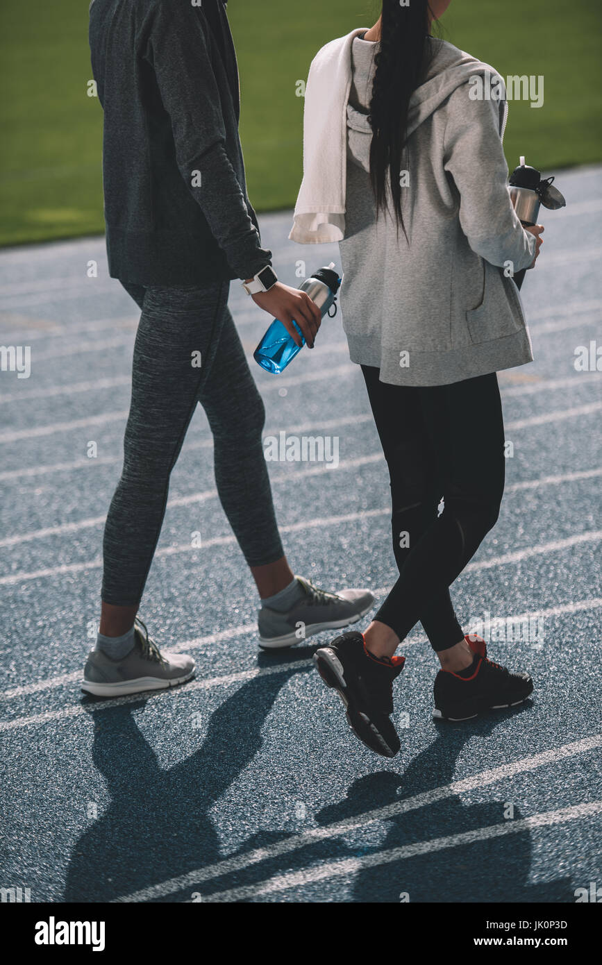 Two young sportswomen walking together on running track stadium Stock ...