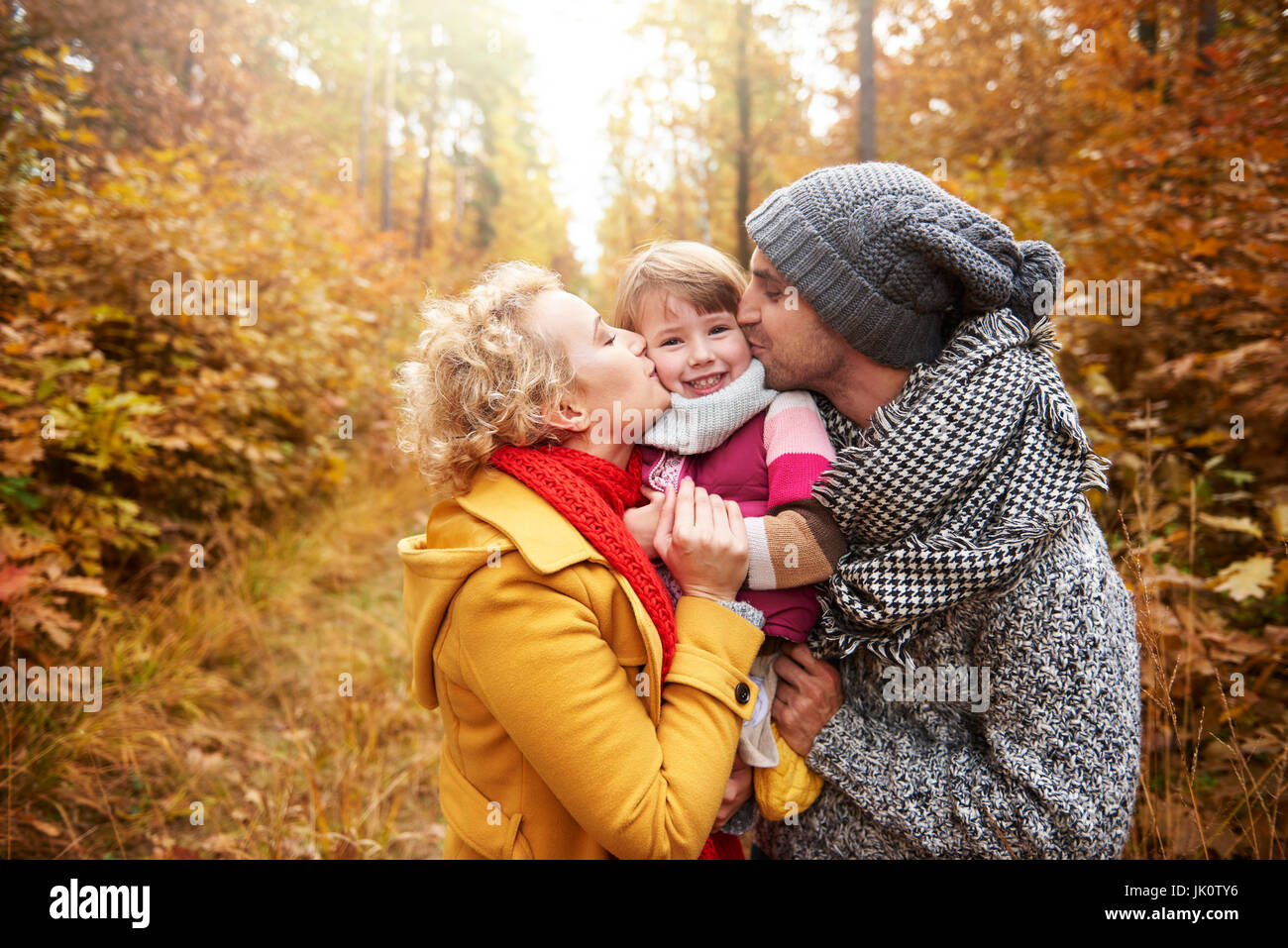 Joyful scene of parents kissing daughter Stock Photo - Alamy
