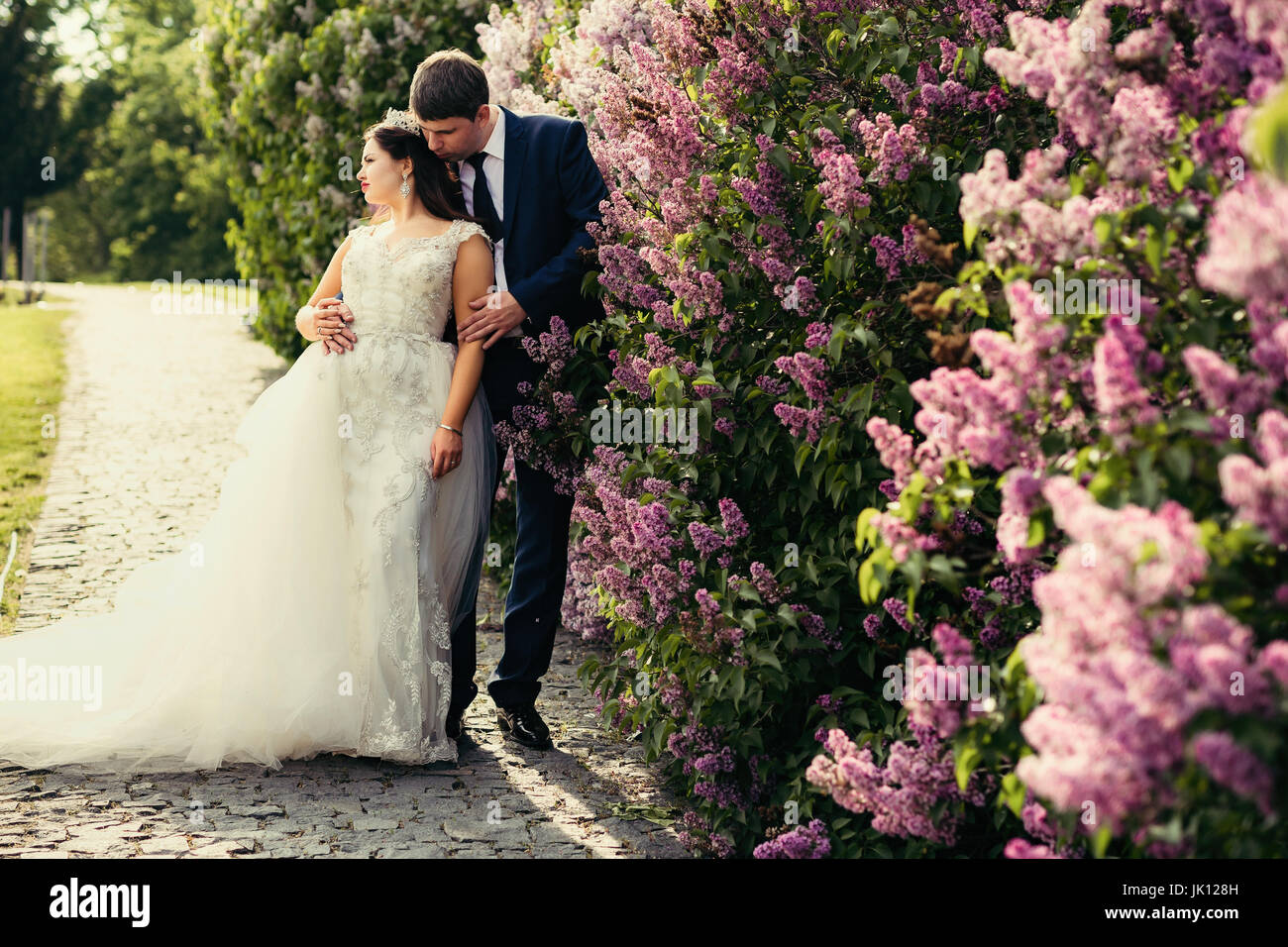 The horizontal photo of the groom hugging the dreamy bride back near ...