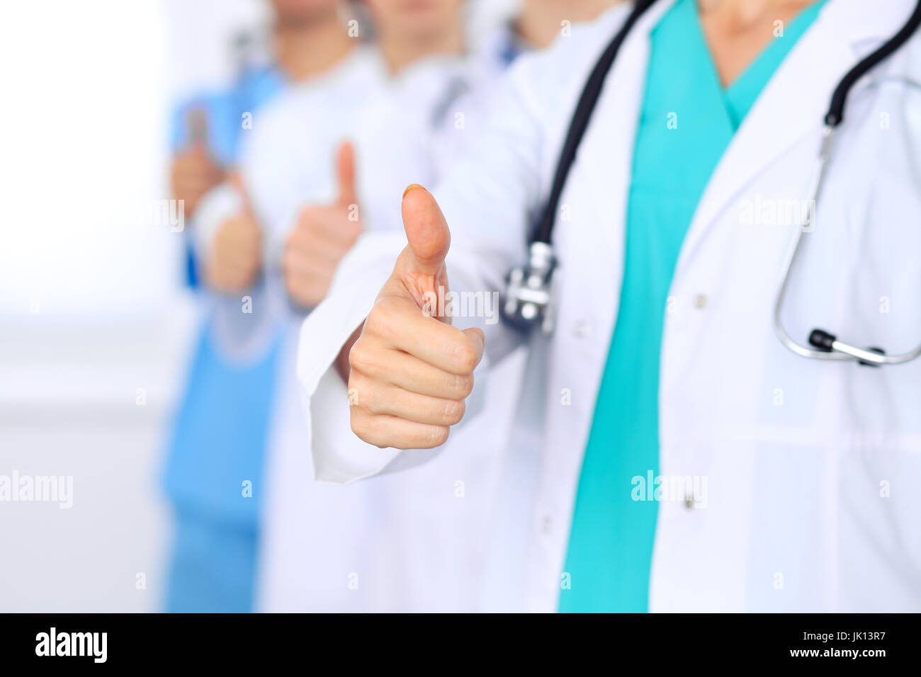 Group of doctors showing OK or approval sign with thumb up. High level ...