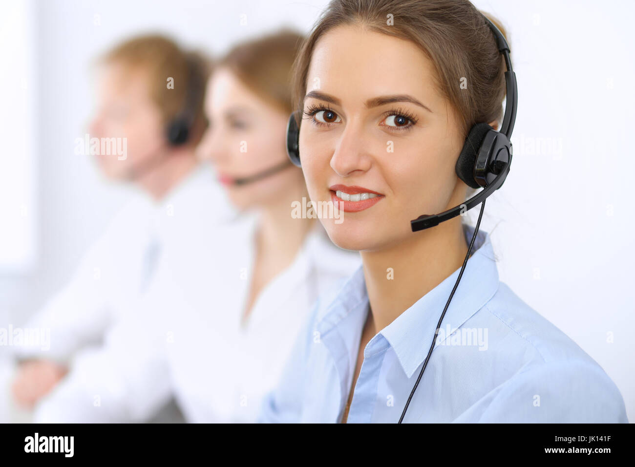 Call center. Focus on beautiful woman in headset Stock Photo - Alamy