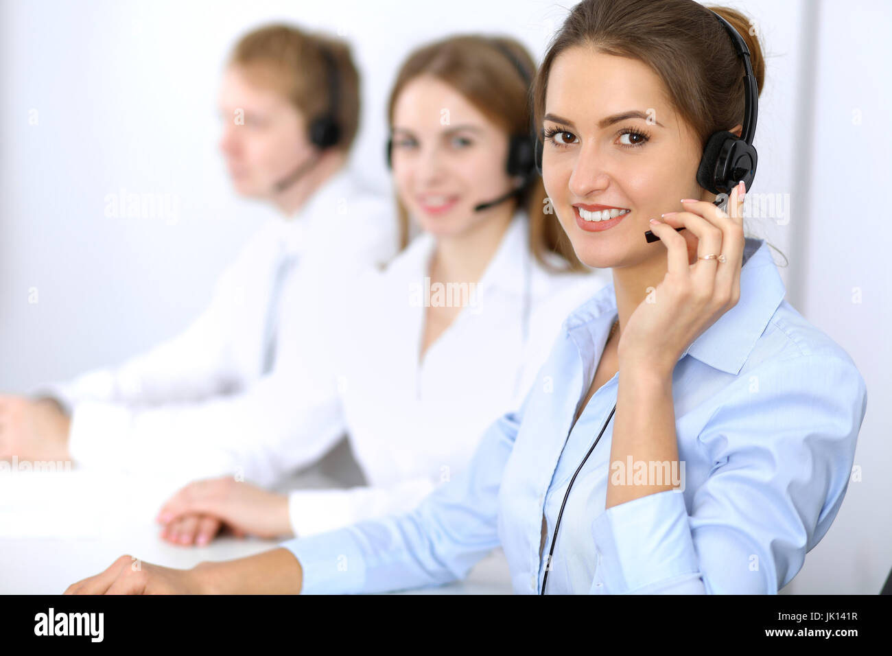 Call center. Focus on beautiful woman in headset Stock Photo - Alamy