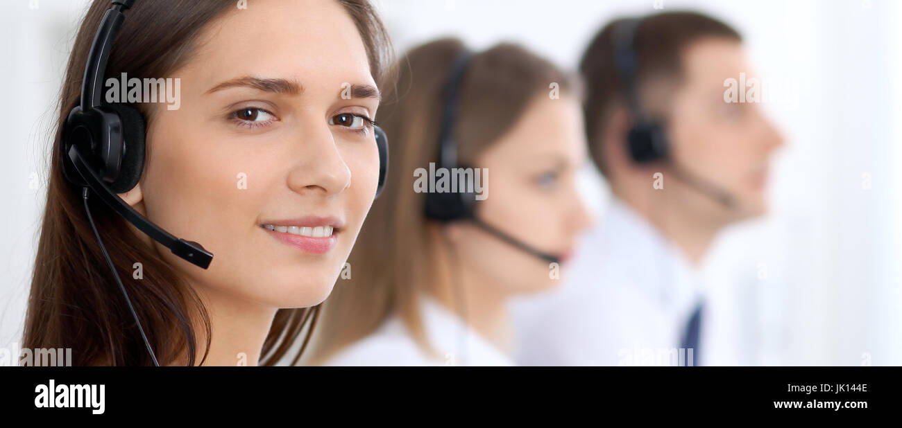 Call center operators. Focus at young beautiful business woman in ...