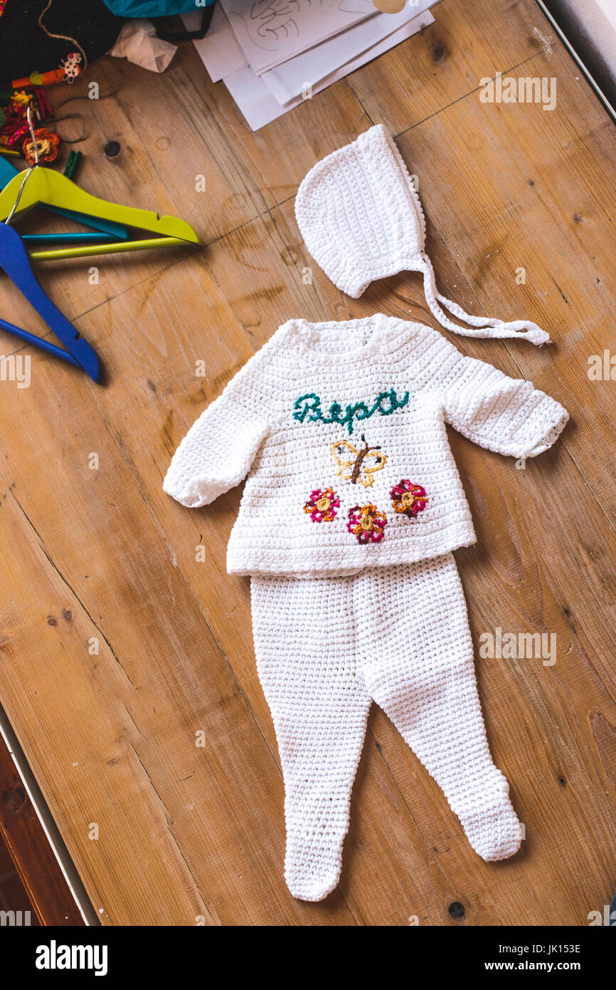 baby clothes on a wooden table with color hangers Stock Photo - Alamy