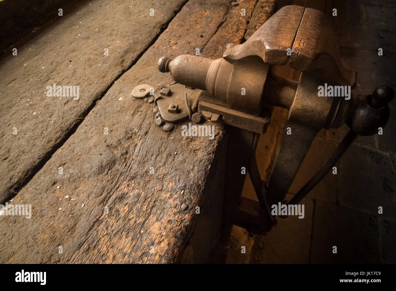 Old metal vice attached to workbench made from worn wooden sleepers ...