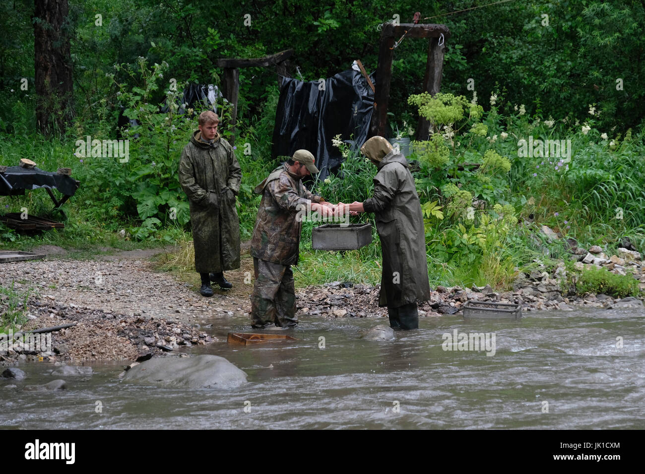 Russian archeologists filtering water in Anuy river at the bottom of ...