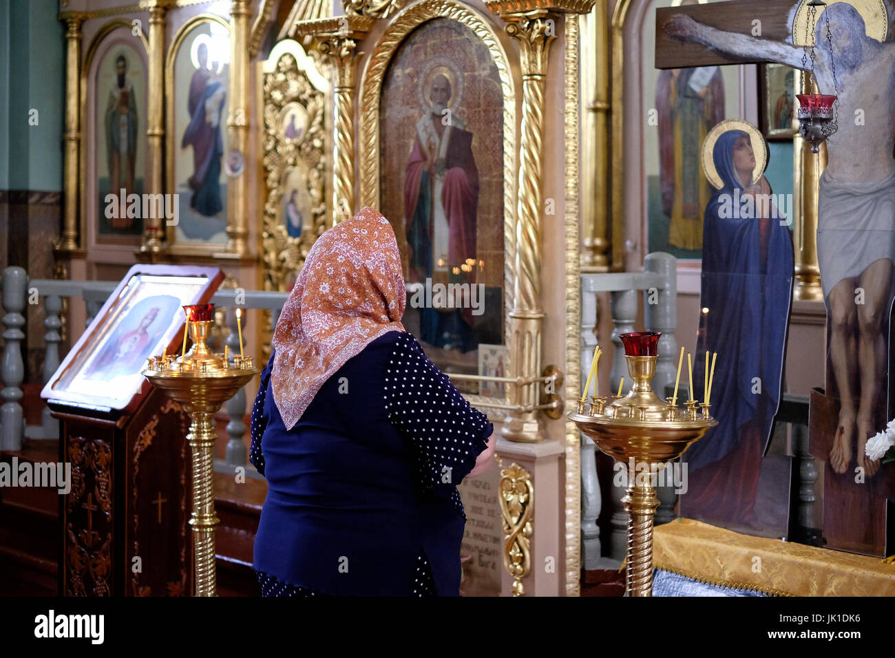 An elderly Russian woman prays in front of religious icon inside the ...
