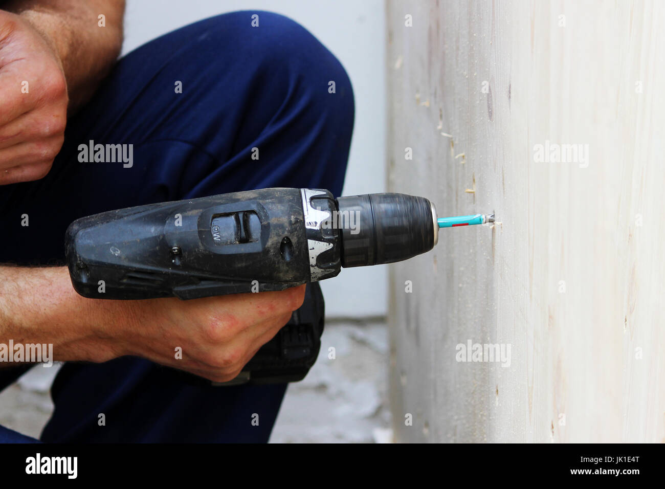 The worker screws screw with a screwdriver while decorating the window ...