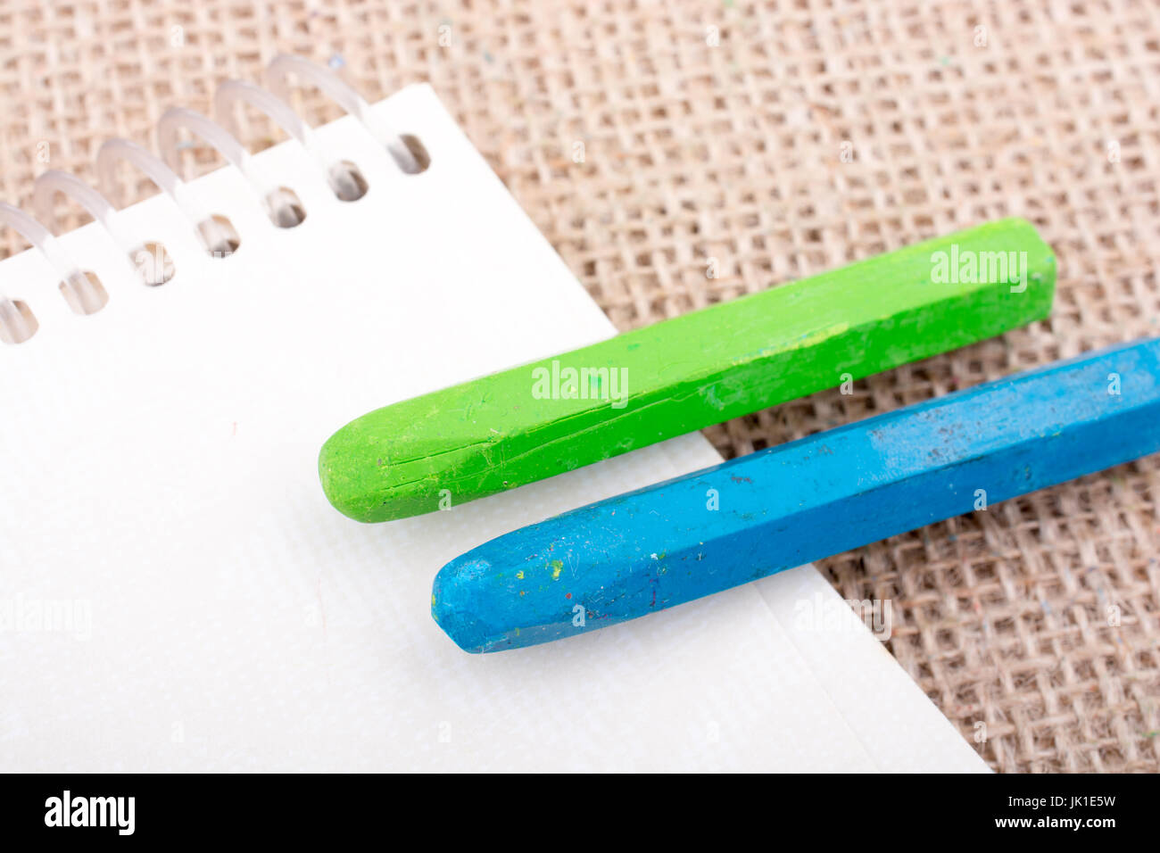 Colorful crayons placed on the notebook Stock Photo - Alamy