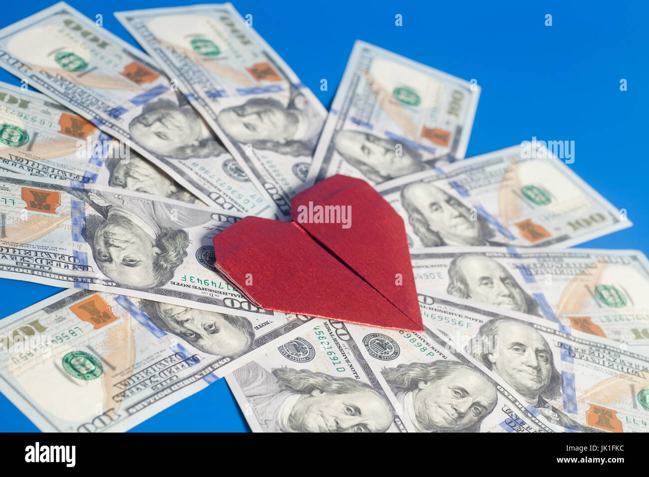 Red paper heart origami and dollar bills on blue background Stock Photo ...