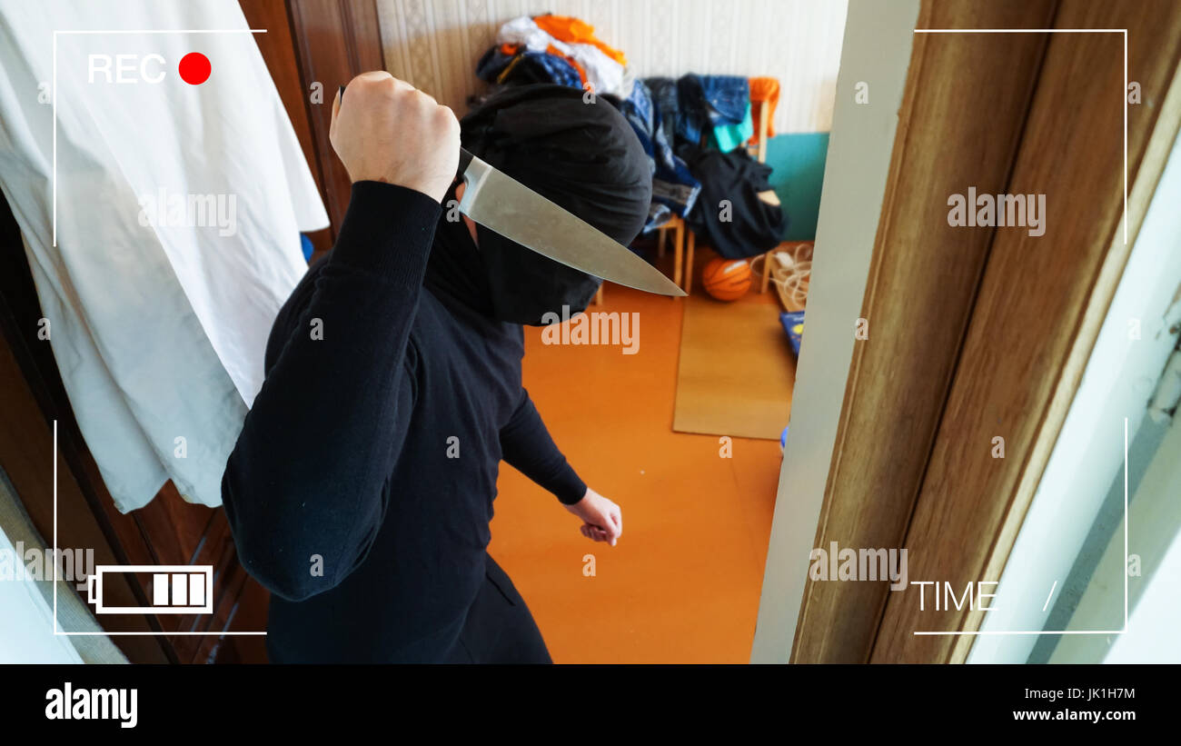 surveillance camera caught the robber in a mask with a knife Stock ...
