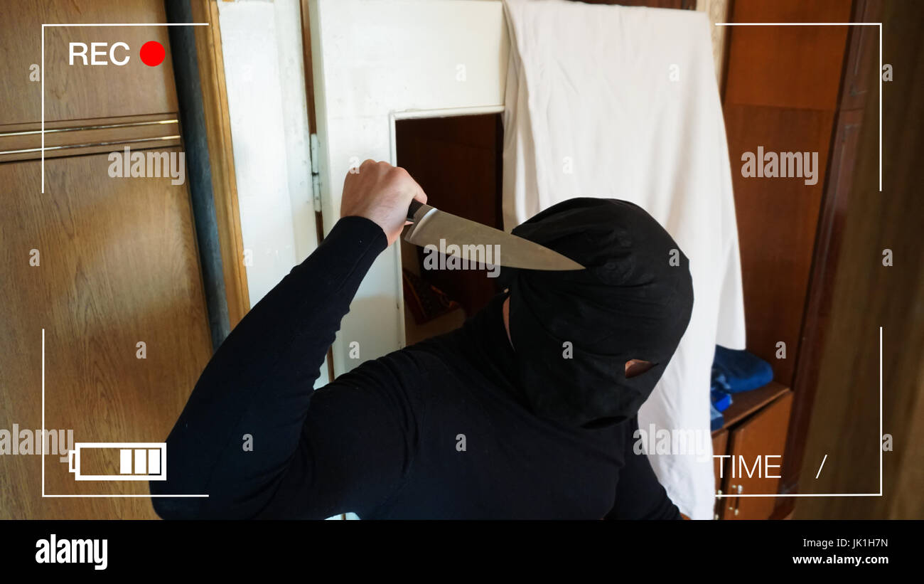 surveillance camera caught the robber in a mask with a knife Stock ...