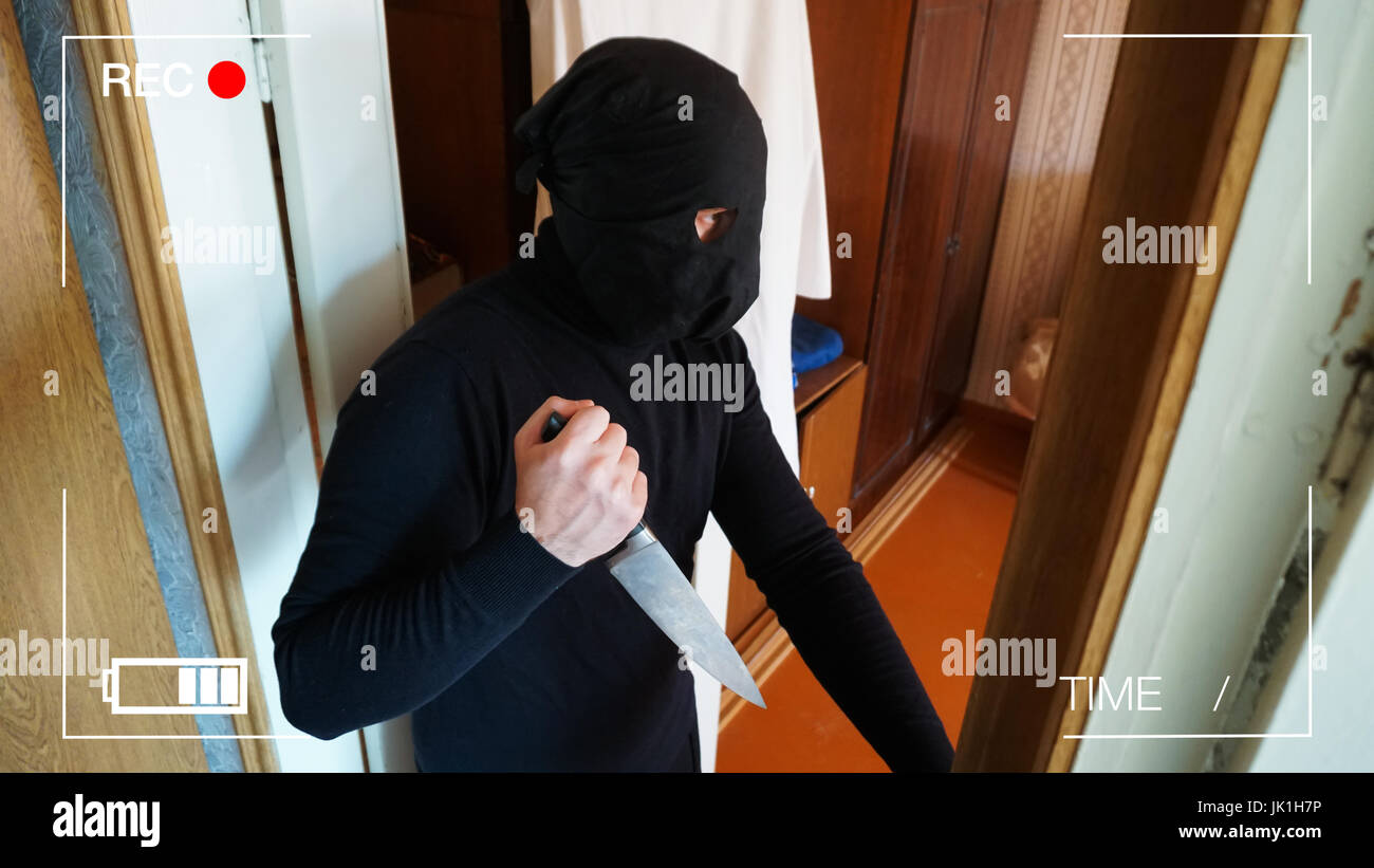 surveillance camera caught the robber in a mask with a knife Stock ...