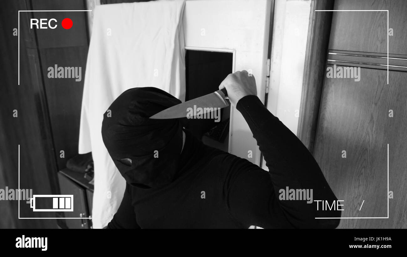 surveillance camera caught the robber in a mask with a knife Stock ...